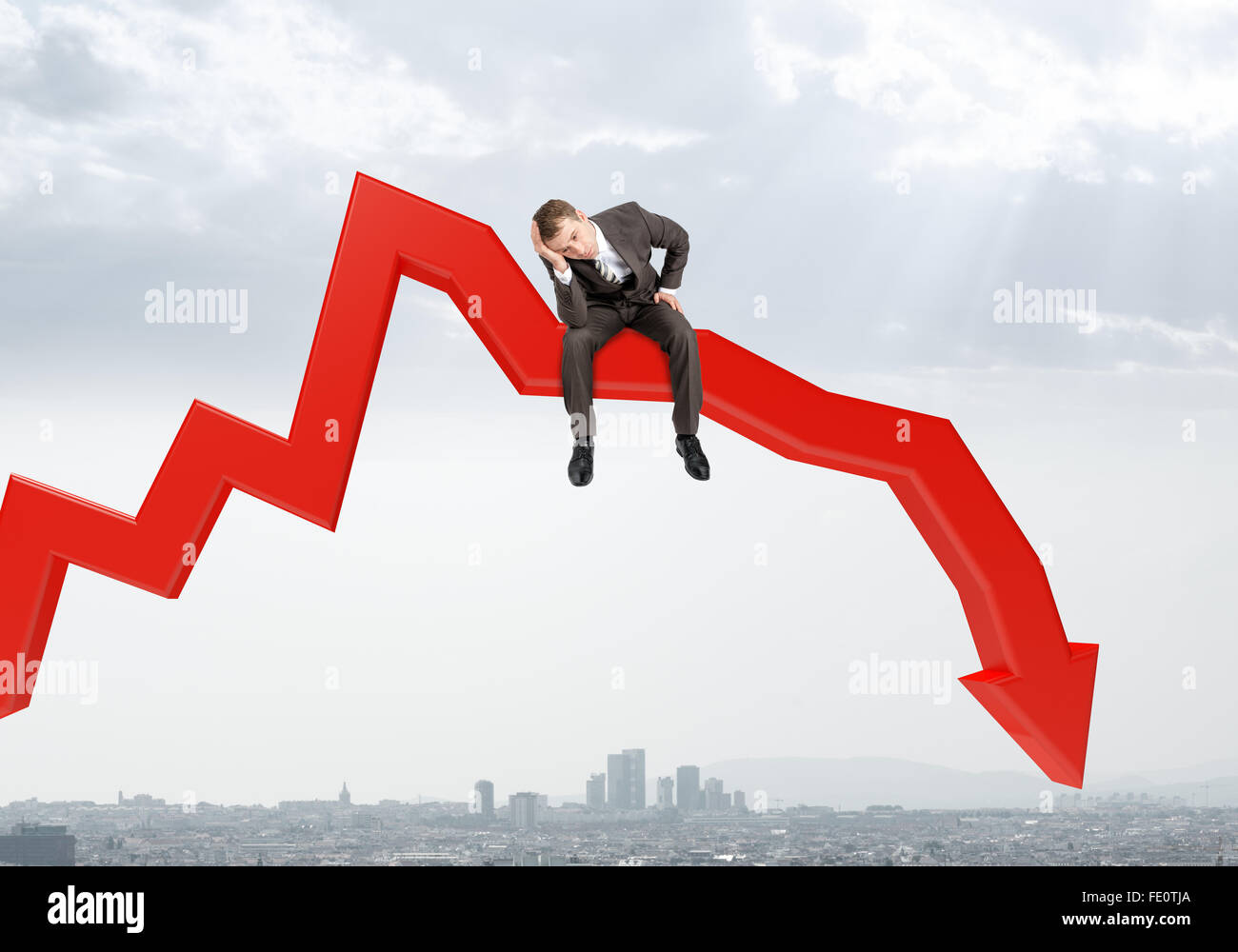 Sad businessman sitting on big red arrow Stock Photo - Alamy
