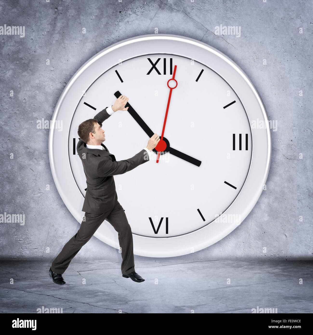 Businessman holding clock hand Stock Photo - Alamy