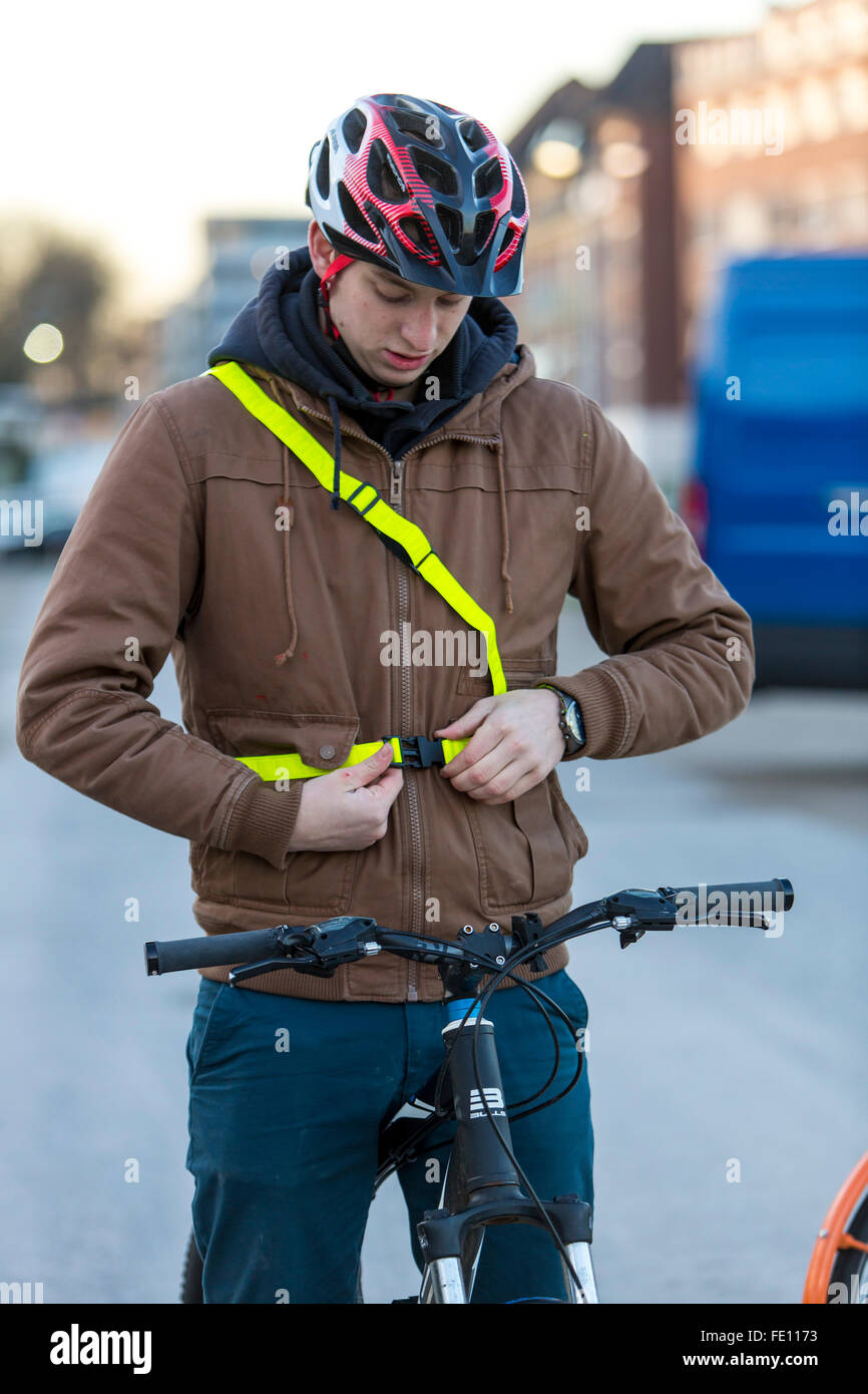 Cyclist put on safety clothing, bike helmet and reflecting vest for ...