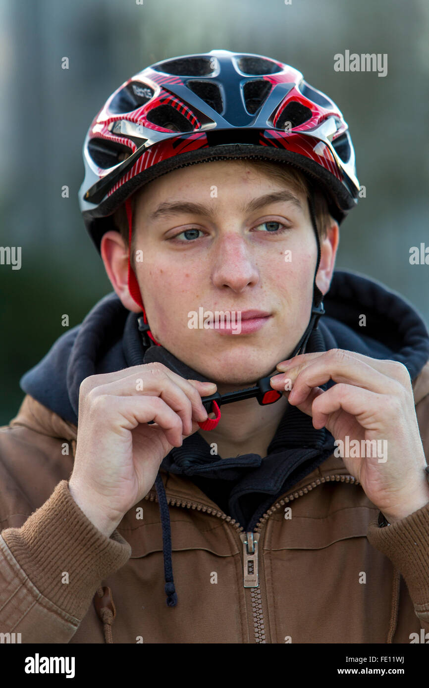 Cyclist put on safety clothing, bike helmet and reflecting vest for bike safety, good visibility ...