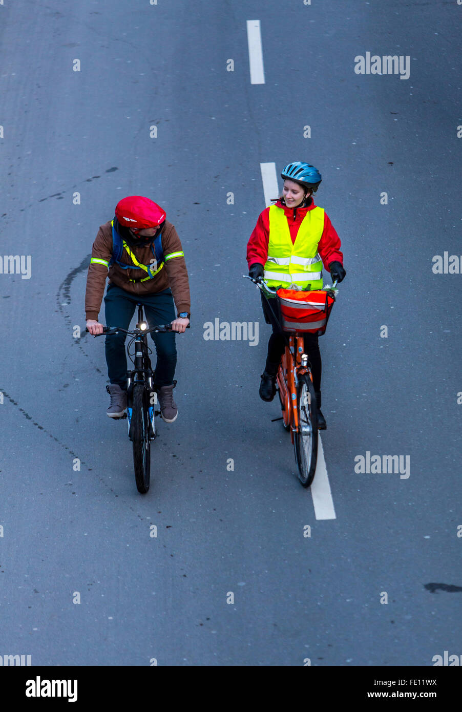Cyclist driving, on a street, with lights and safety clothing, bike ...