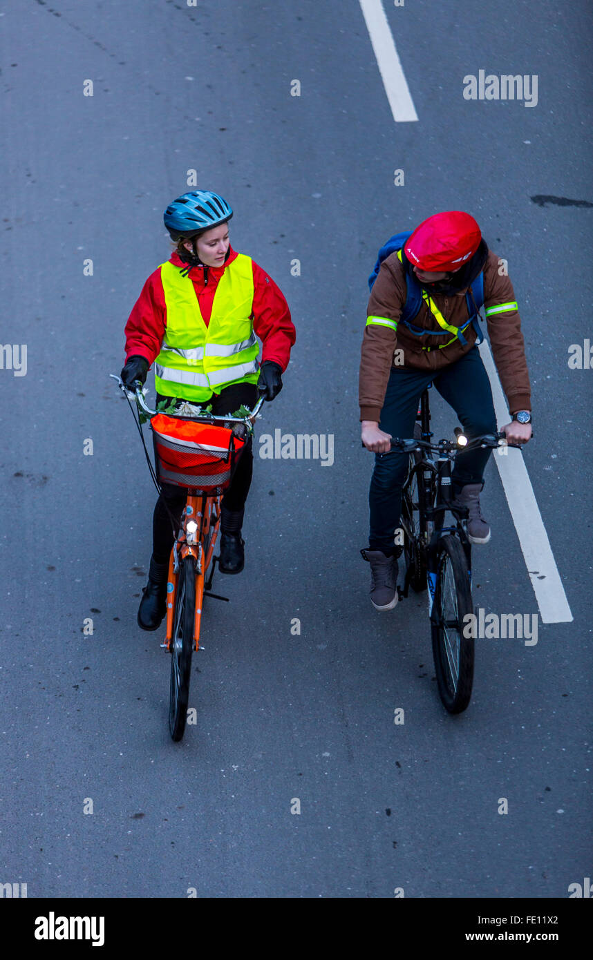 Cyclist driving, on a street, with lights and safety clothing, bike ...