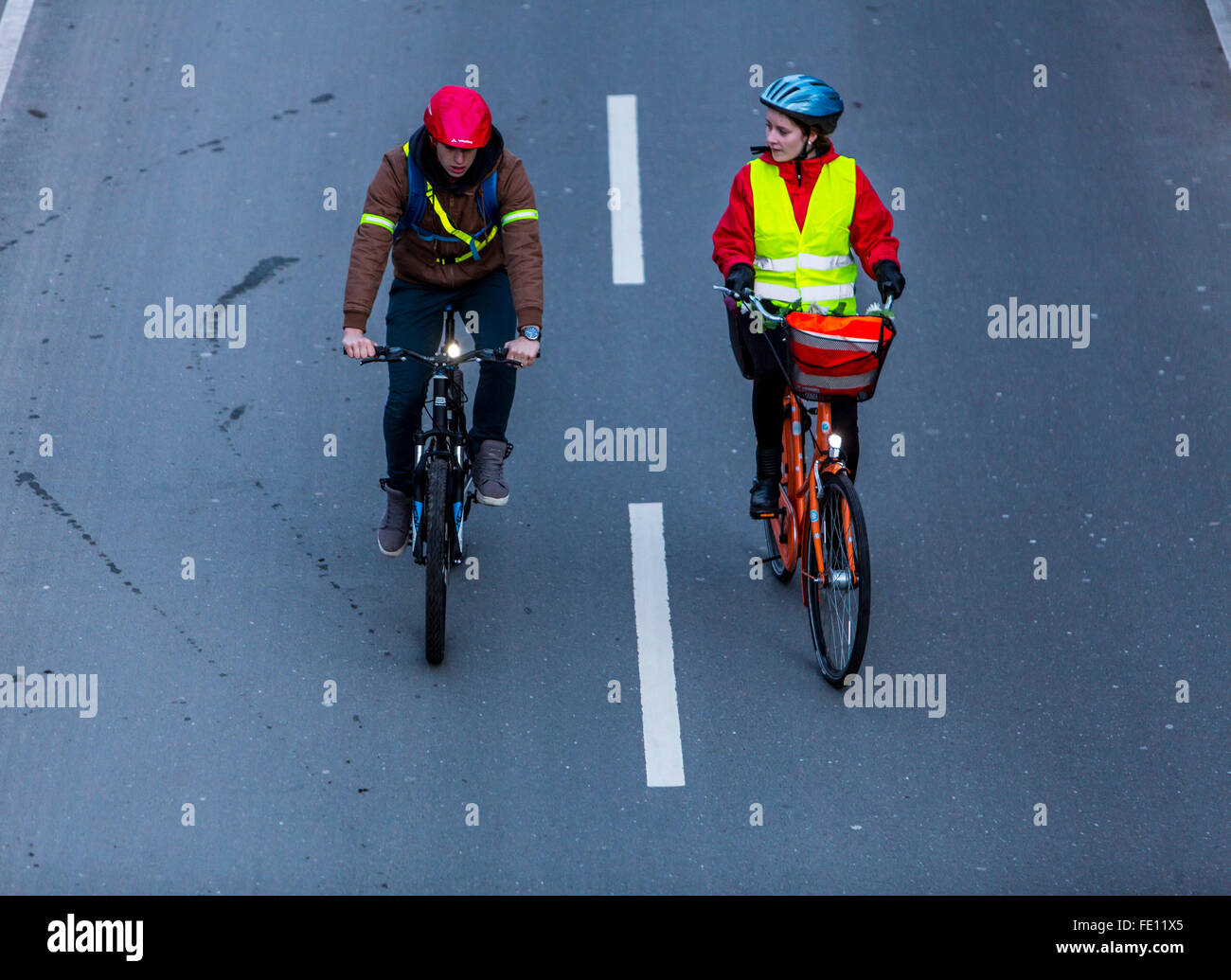Cyclist driving, on a street, with lights and safety clothing, bike ...