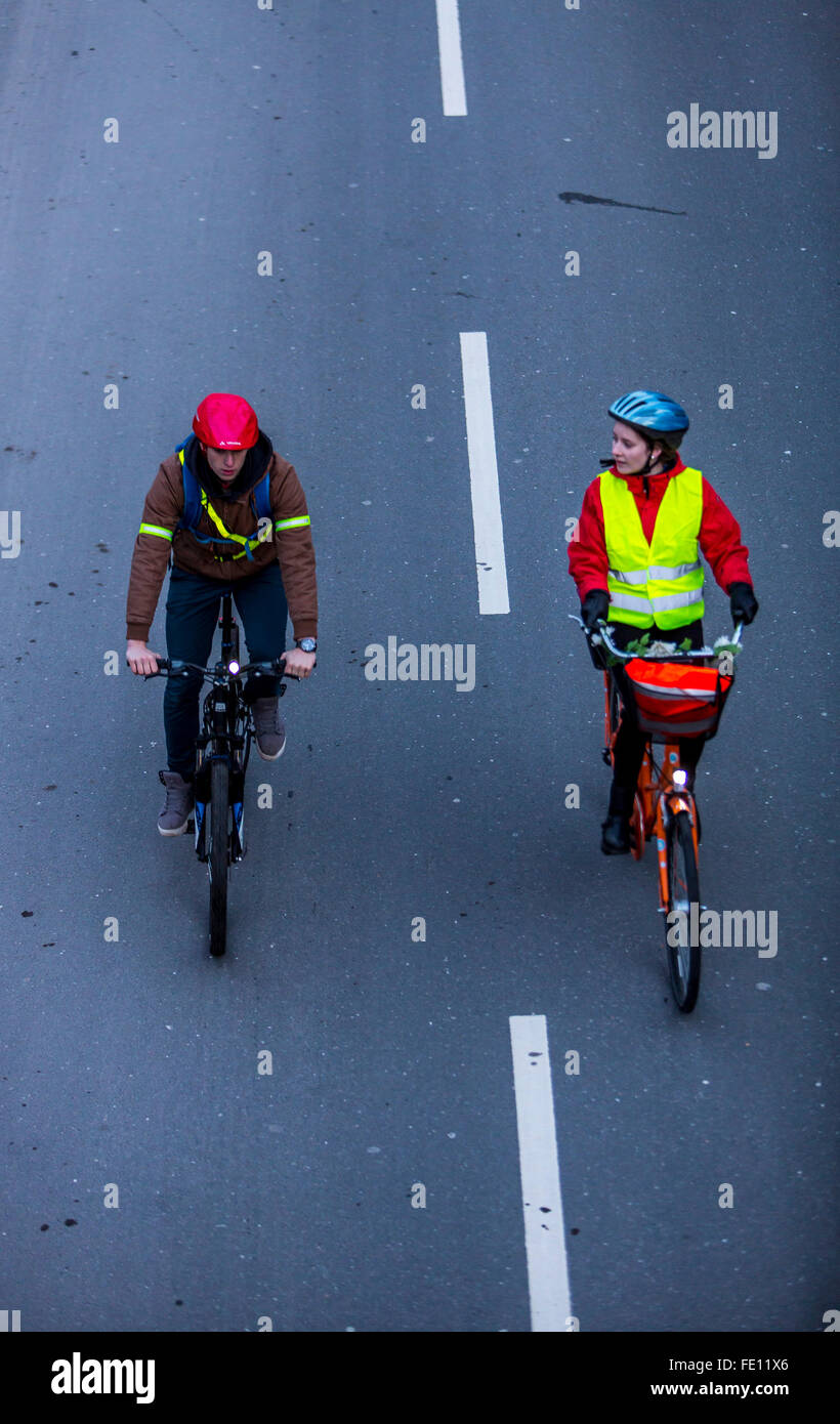 Cyclist driving, on a street, with lights and safety clothing, bike ...