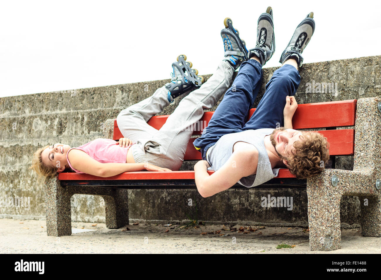 Young tired people friends in training suit with roller skates. Woman ...
