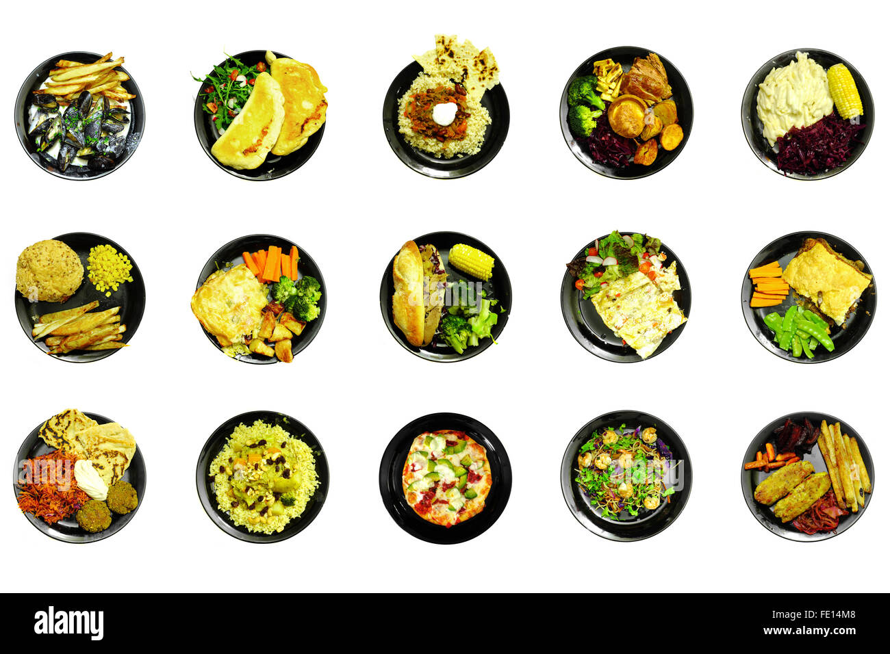 Different meals on black plates photographed against a white background ...