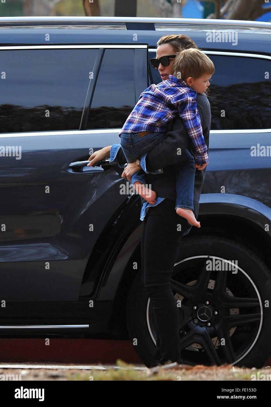 Jennifer Garner carries her son, Samuel, back to her car after taking ...