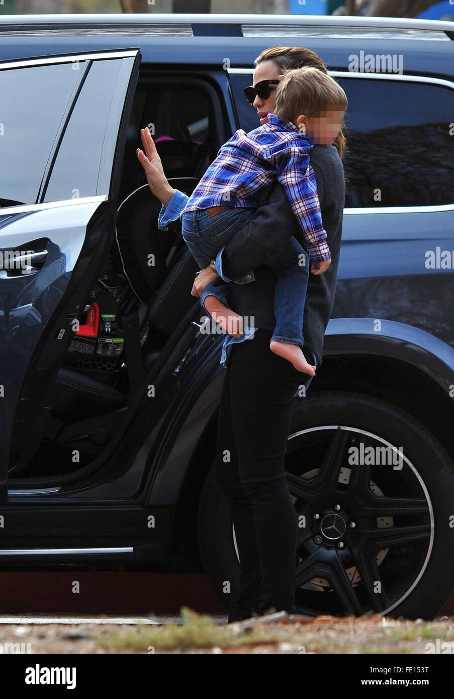 Jennifer Garner carries her son, Samuel, back to her car after taking ...
