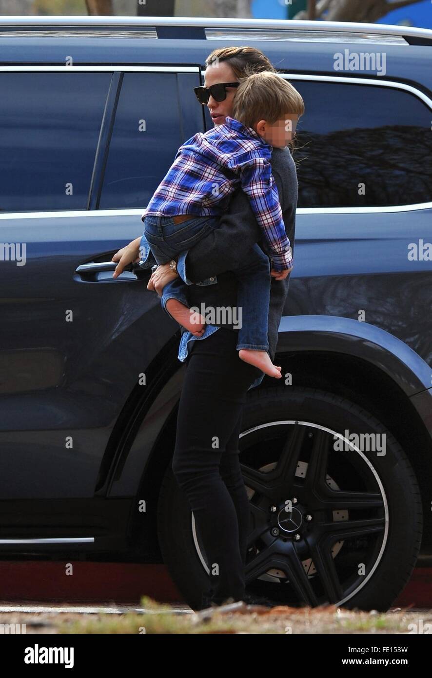 Jennifer Garner carries her son, Samuel, back to her car after taking ...