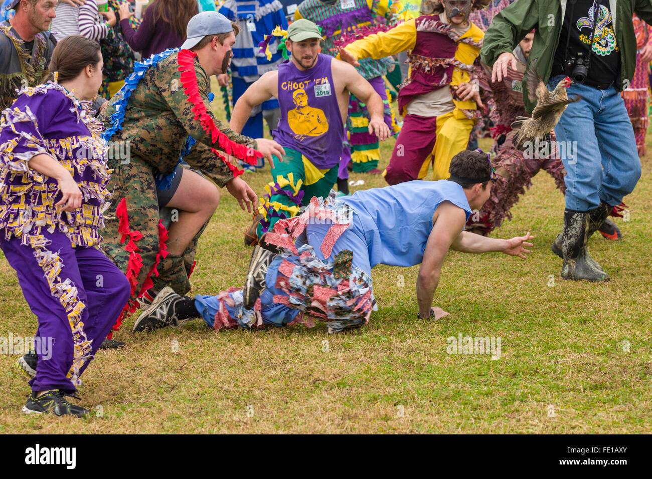 Revelers try to grab a live chicken during the traditional Cajun Courir ...