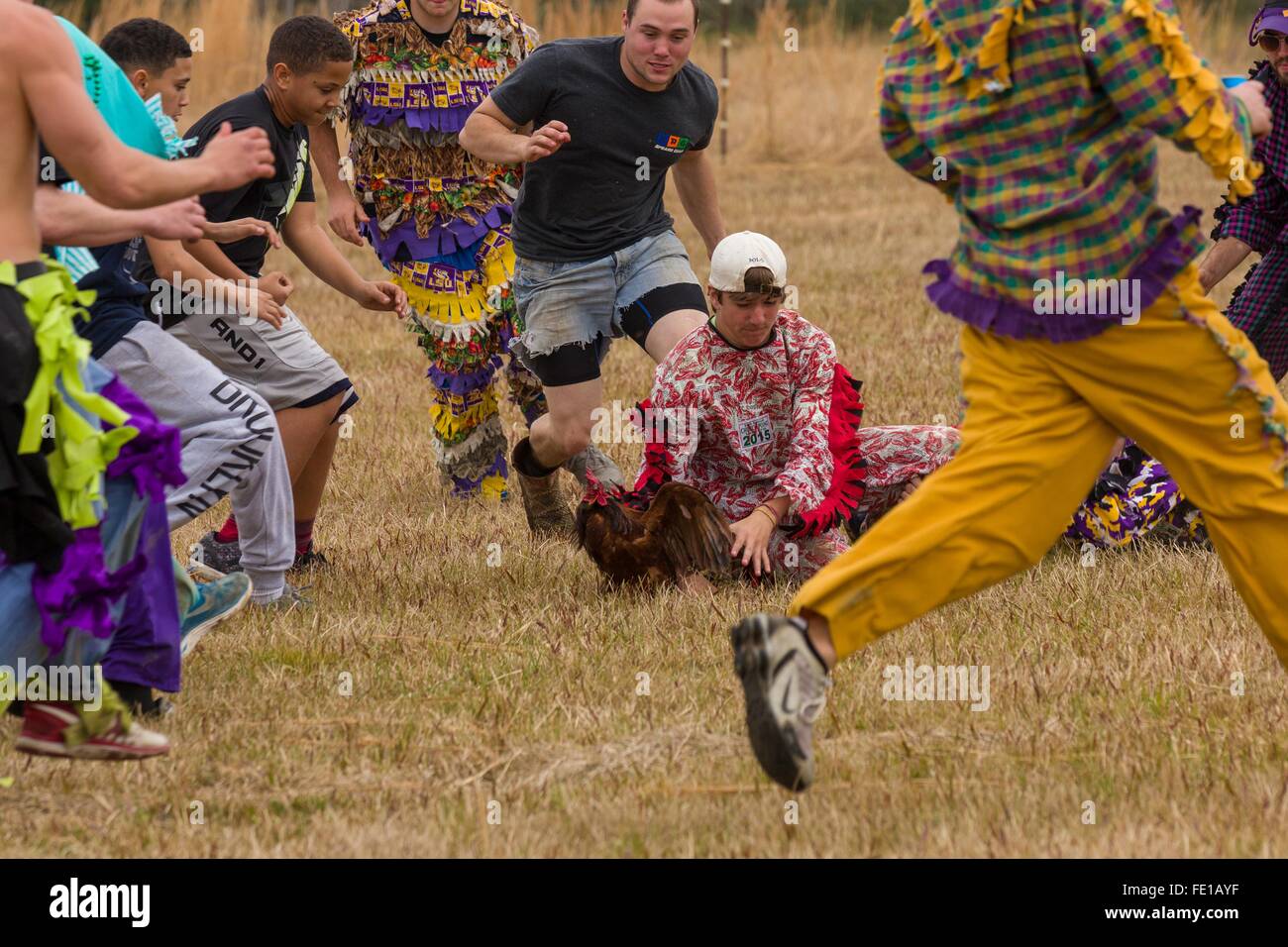 Revelers try to grab a live chicken during the traditional Cajun Courir ...