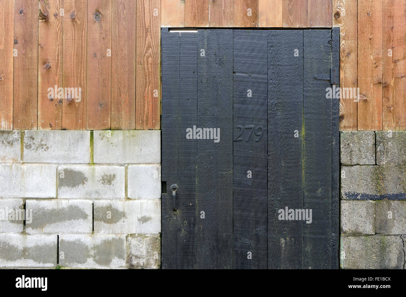 Black wooden door in a building constructed of concrete blocks and ...
