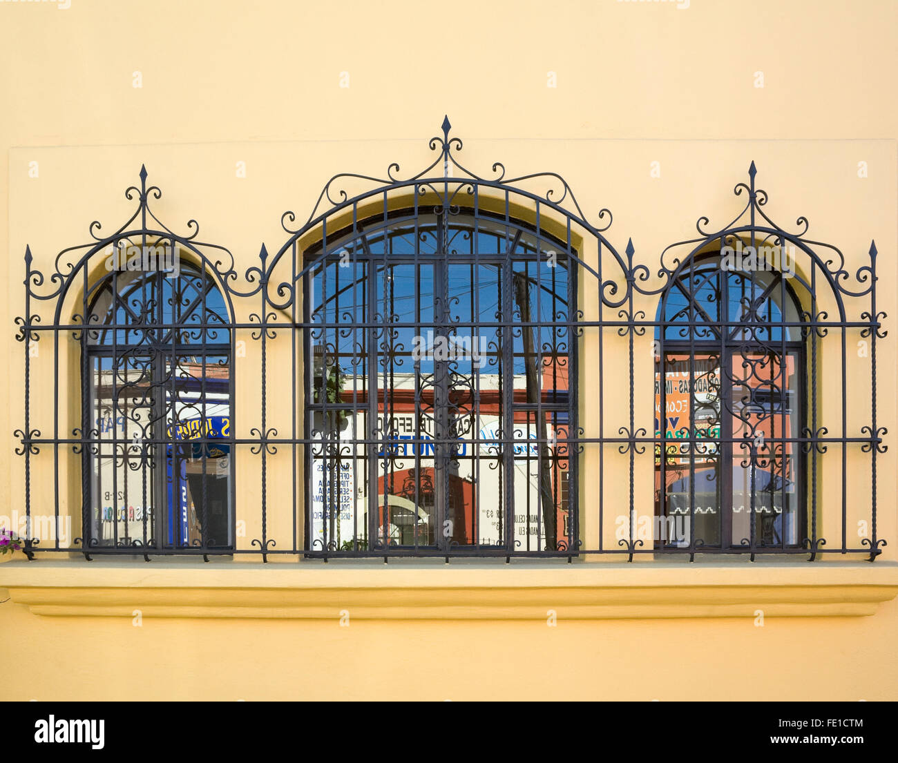 Street scene reflected in arched windows with ornate wrought iron ...