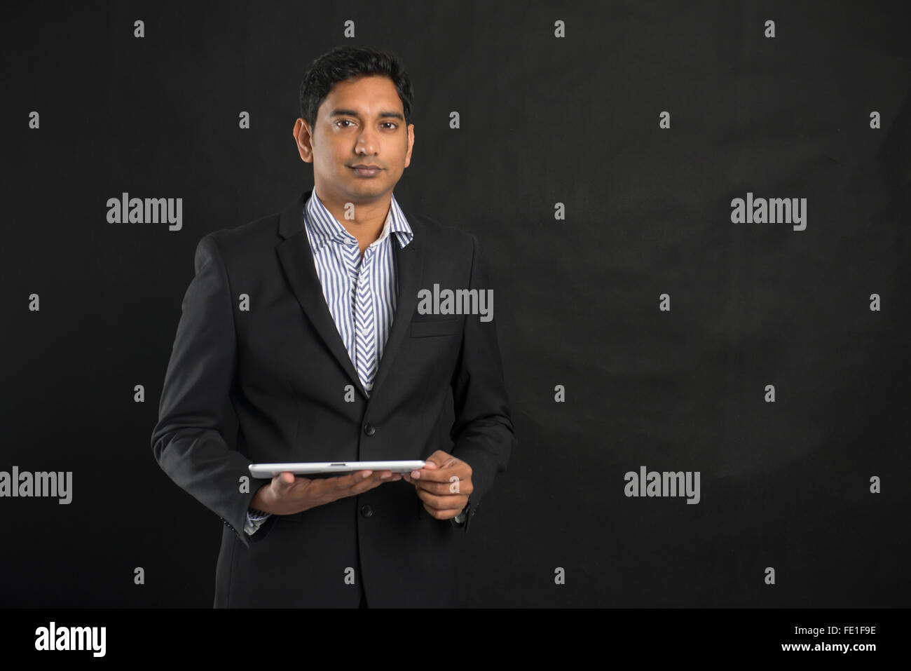 indian business man with a tablet and dark background Stock Photo - Alamy