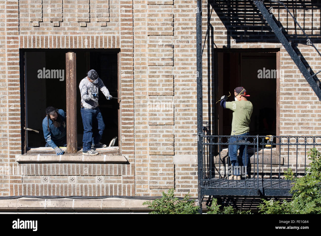 Two Construction Workers removing the windows from an apartment ...