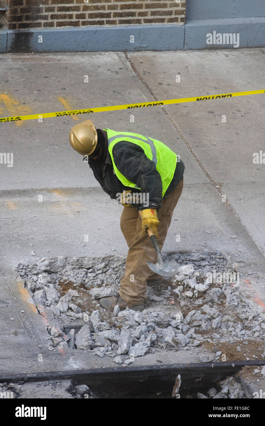 Construction Worker manually removing broken concrete debris from a ...