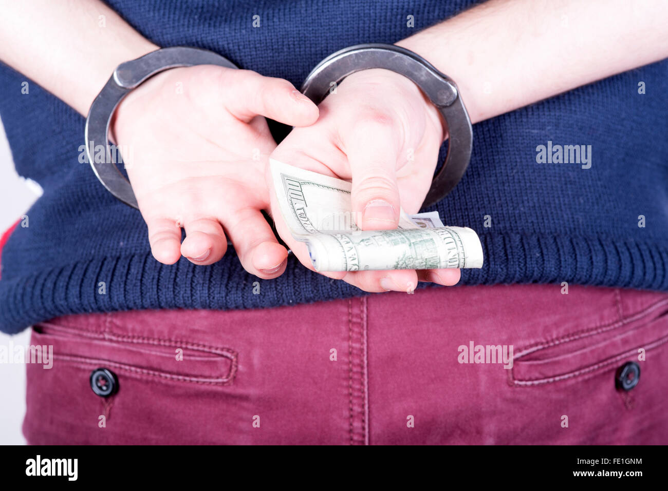 a picture of a criminal locked in handcuffs trying to bribe Stock Photo ...