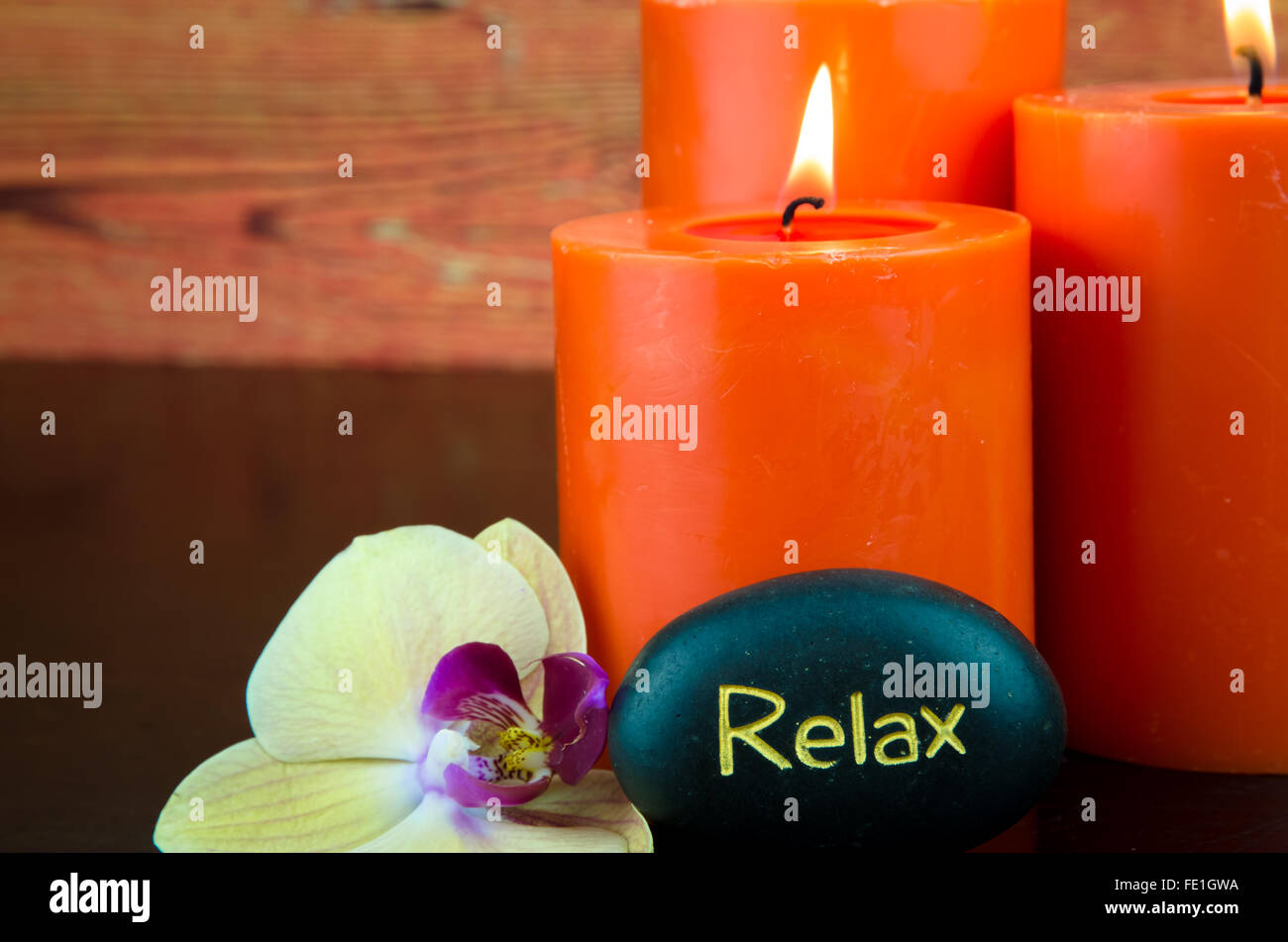 burning orange candles and black lava stone Stock Photo - Alamy