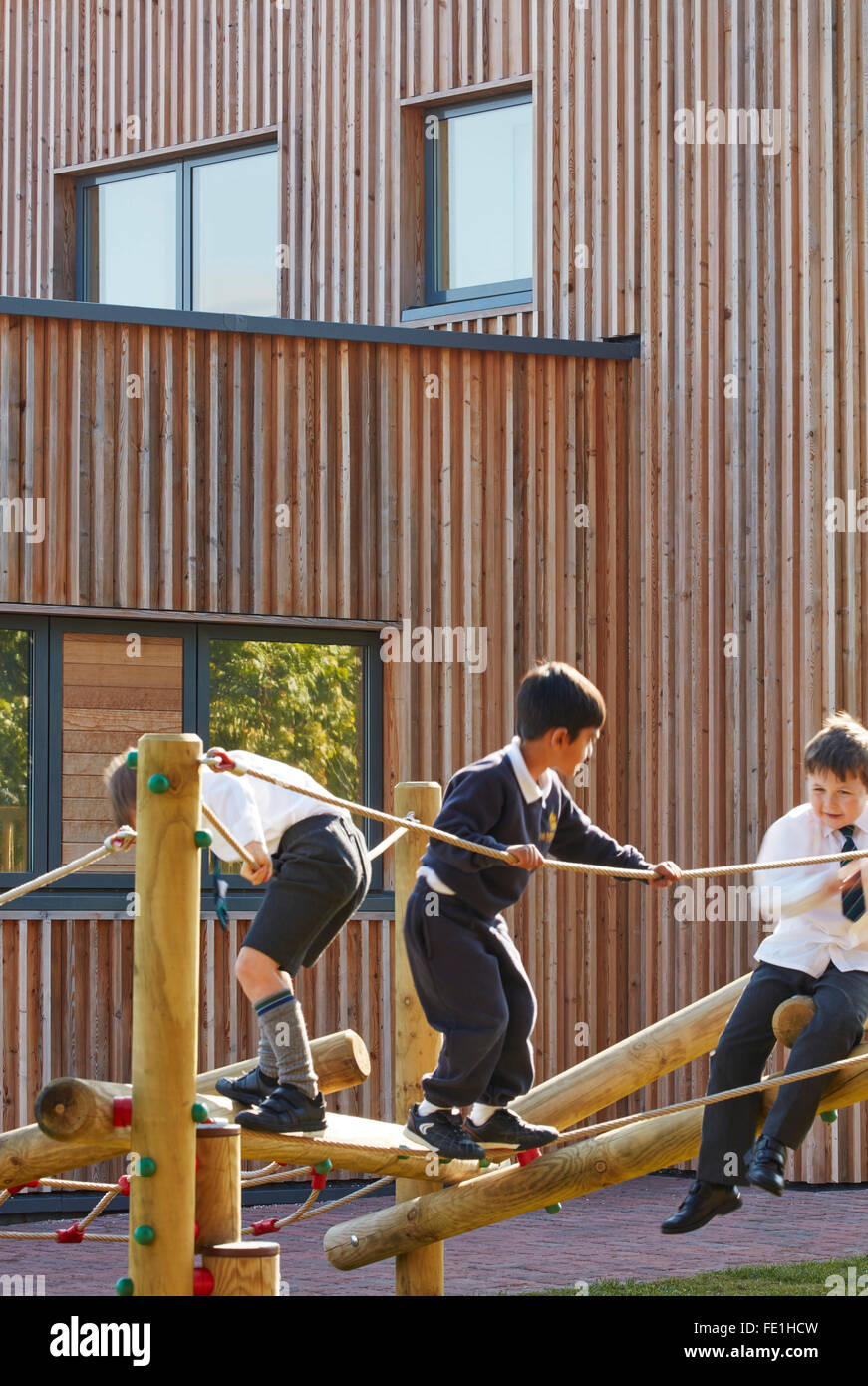 Monkey bars with children in front of building's timber facade. Willow ...