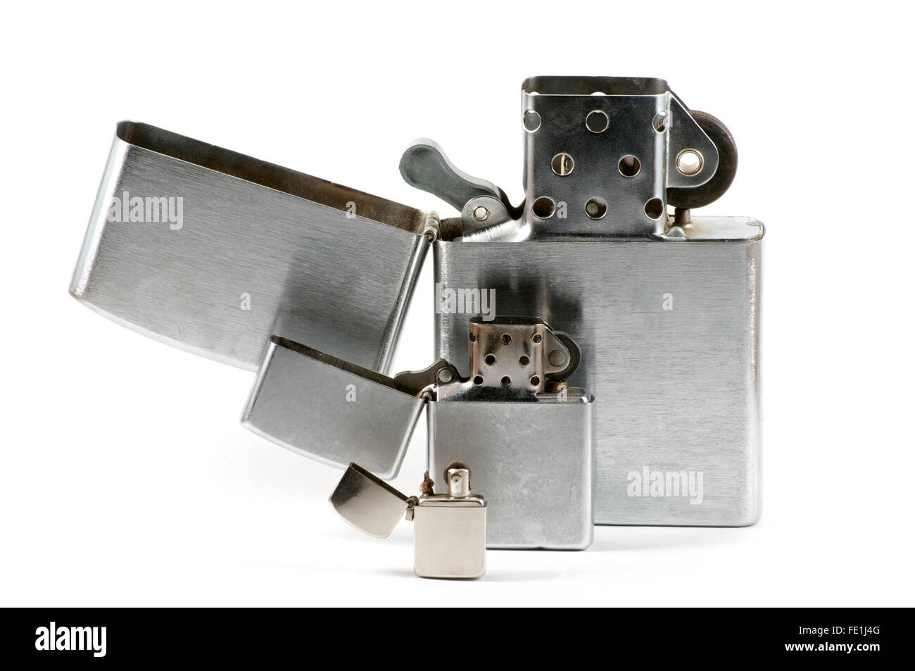 Three different sizes of metallic lighters with cap closed over white ...