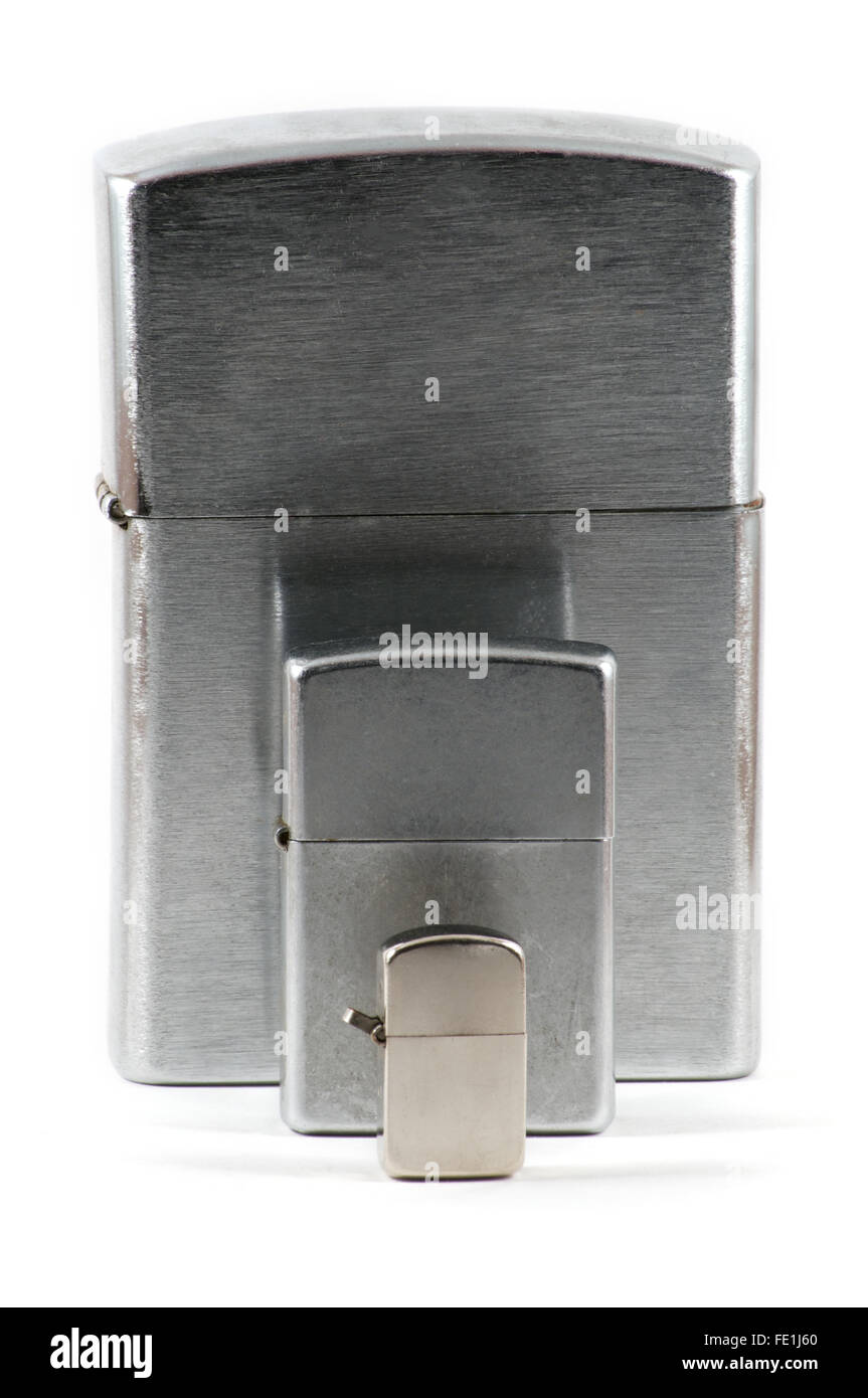 Three different sizes of metallic lighters with cap closed over white ...