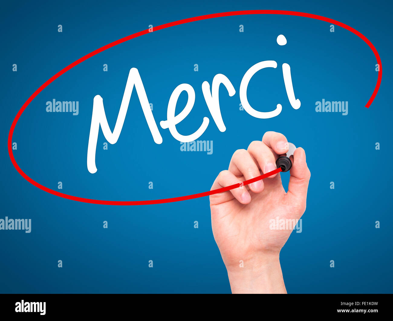 Man Hand writing Merci (Thank You In French) with black marker on ...