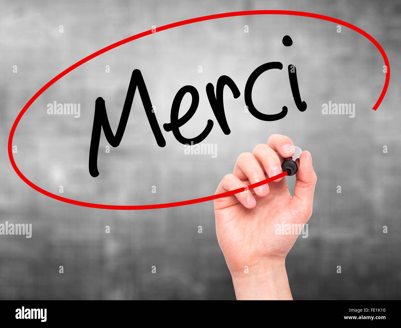 Man Hand writing Merci (Thank You In French) with black marker on ...