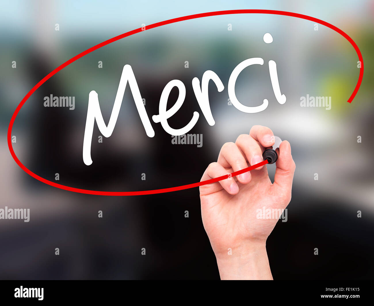 Man Hand writing Merci (Thank You In French) with black marker on ...