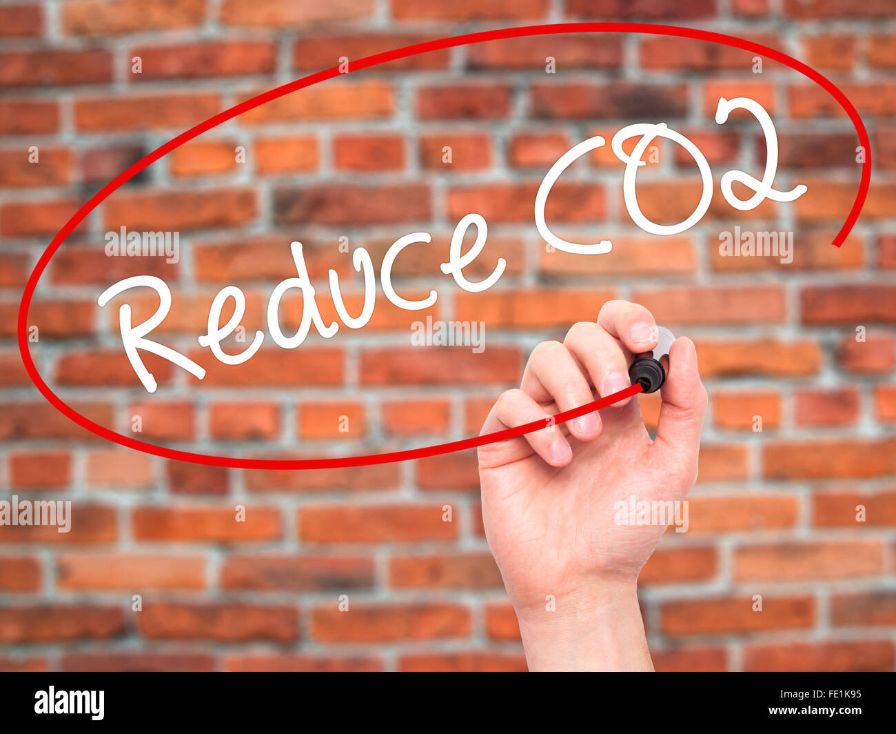 Man Hand writing Reduce CO2 with black marker on visual screen ...