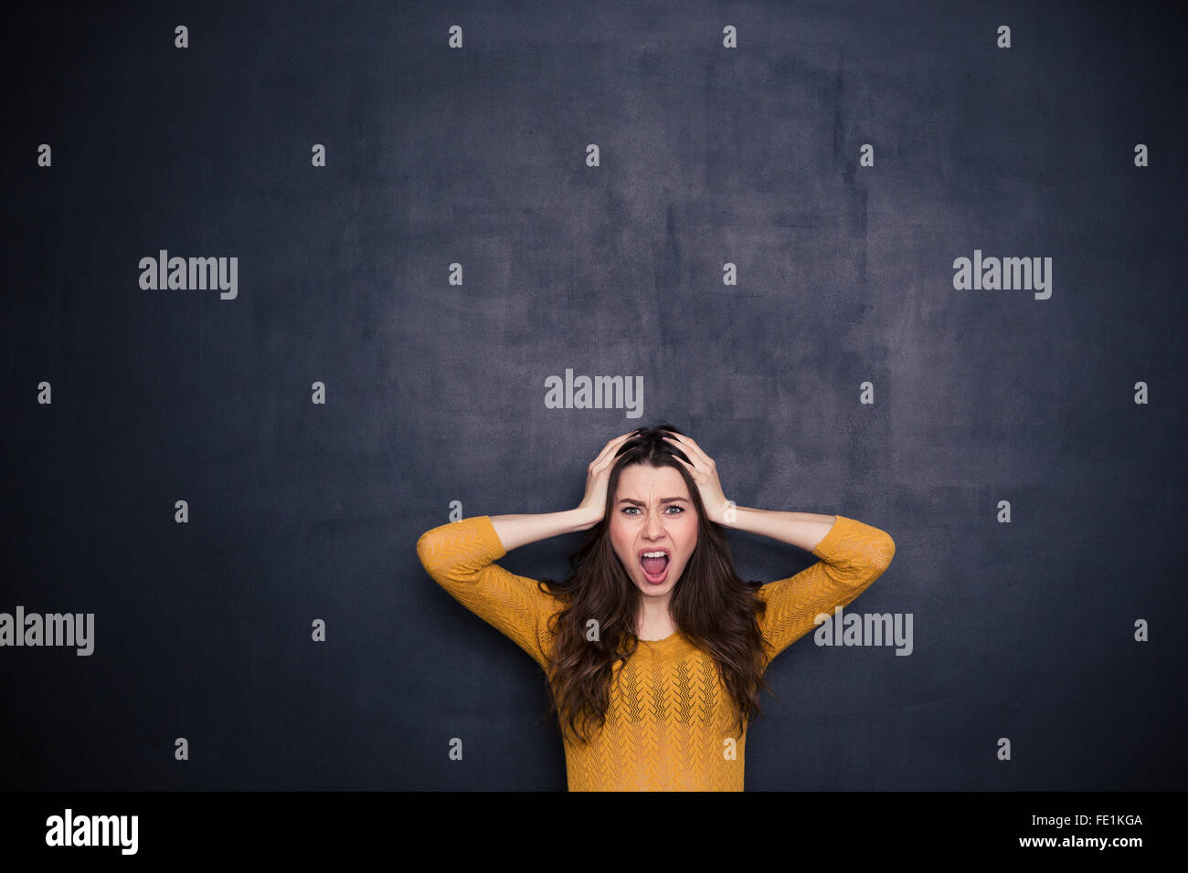 Stressed woman screaming over black background Stock Photo - Alamy