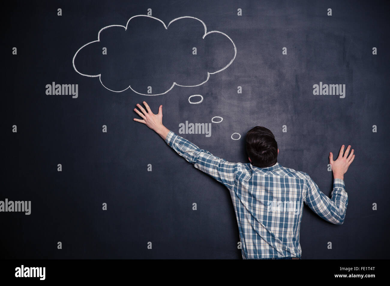 Back view of young man in plaid shirt lying on the floor and crawling ...