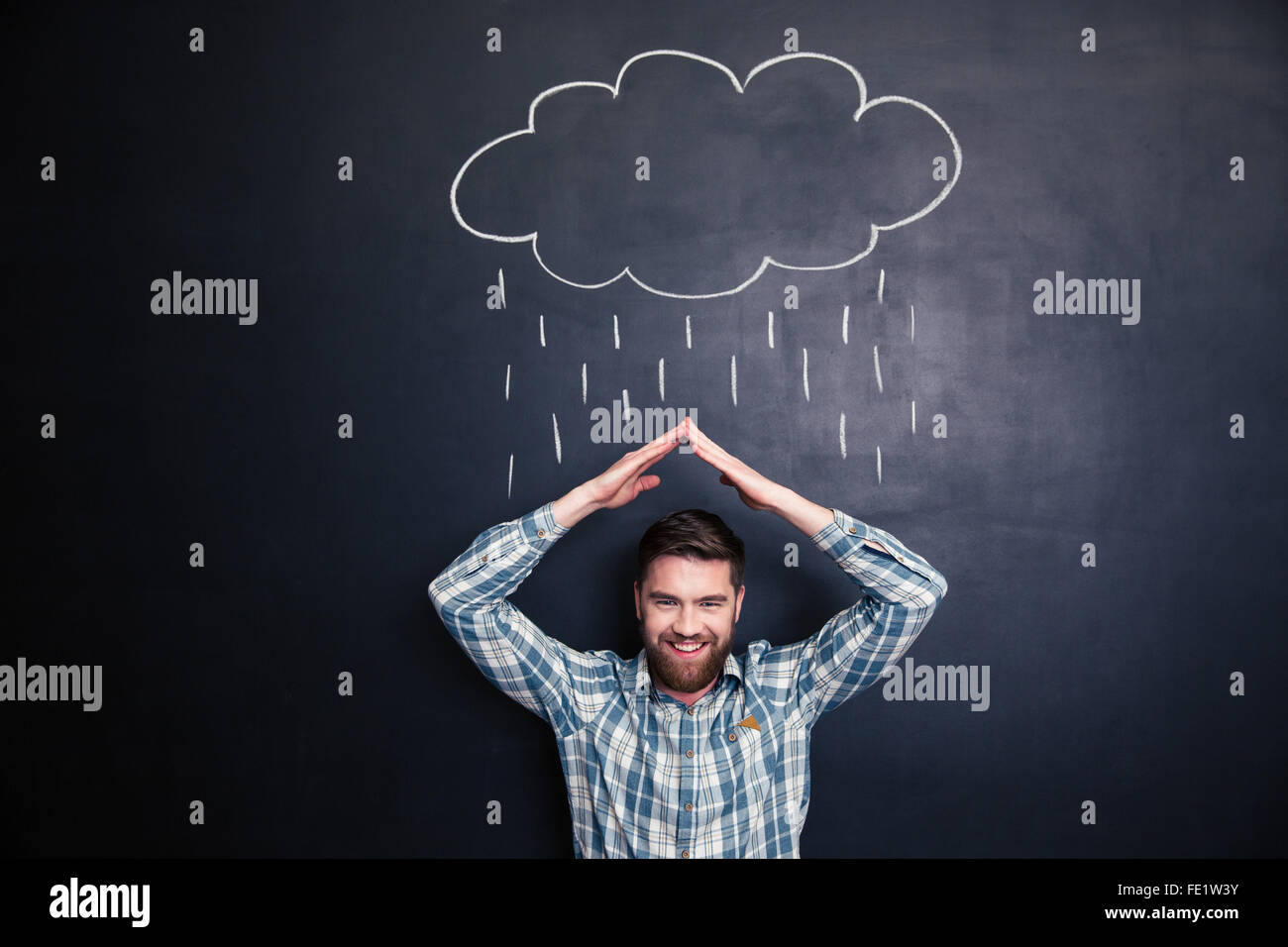 Happy attractive bearded young man imitating roof with hands and ...