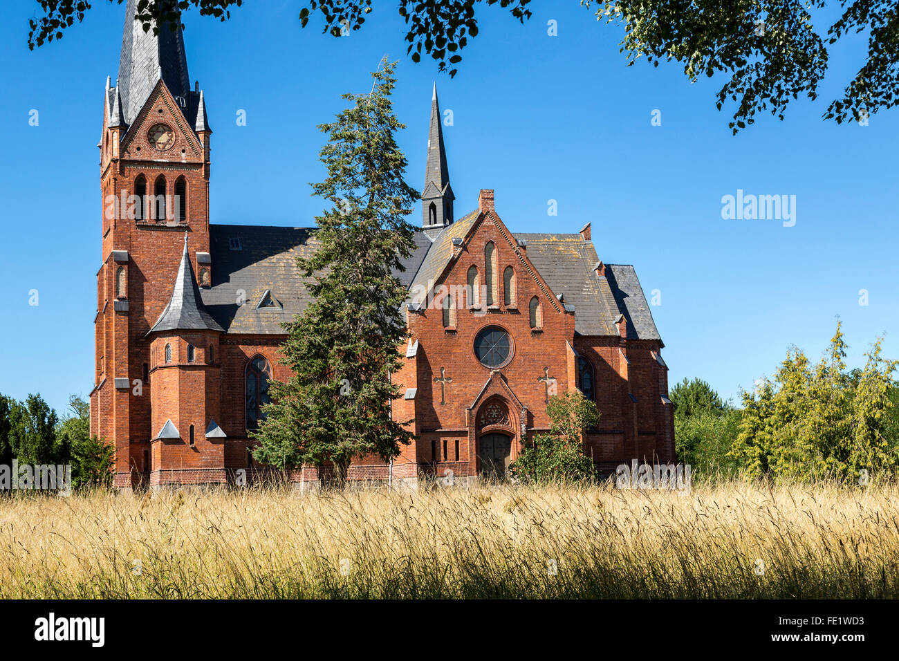 red brick church on a wild meadow Stock Photo - Alamy