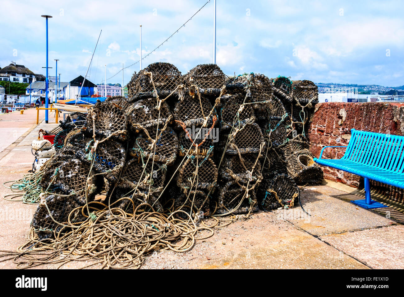 Lobster pots and fishing gear neatly stacked on the harbour side ready ...