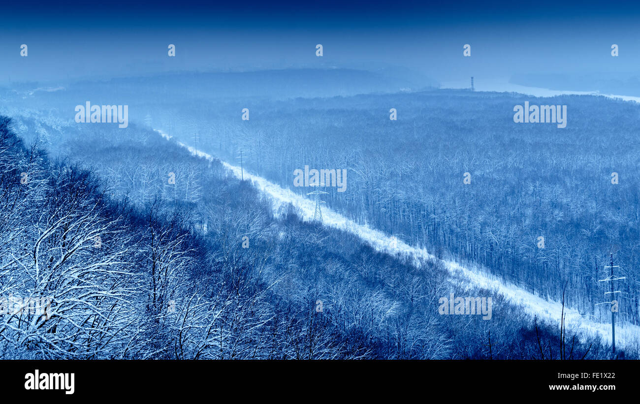 Tree filled landscape caught in the deep winter of Russia. Snow peaks ...