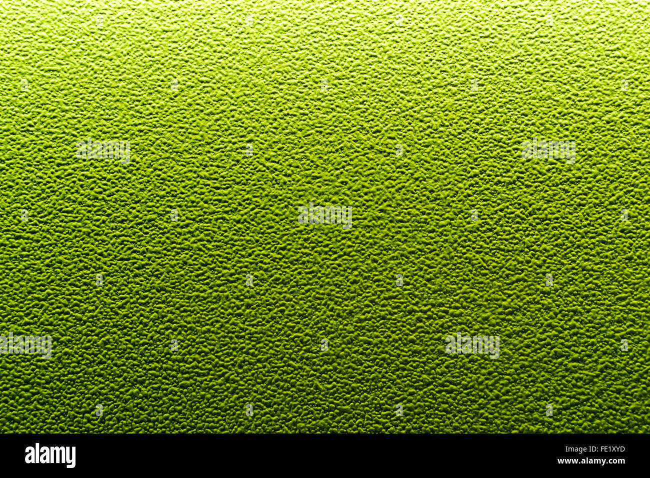 Green brightly lit surface with mottling and bumps from the plaster ...