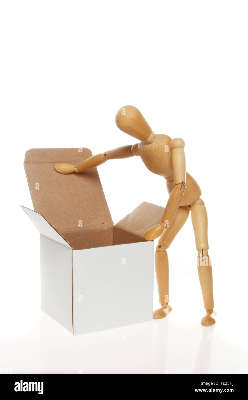 Artist's wooden manikin looks into a cardboard box against a white ...