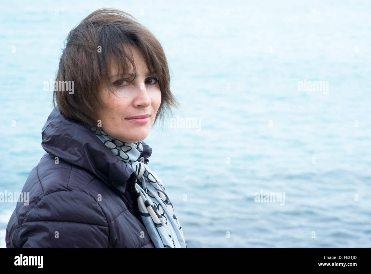 Woman standing in windy conditions in front of the sea Stock Photo - Alamy