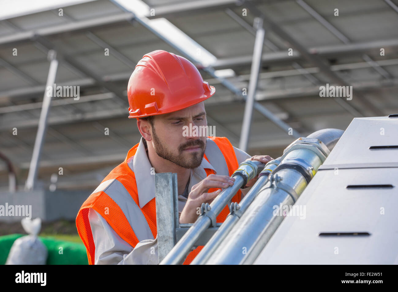Power engineer examining conduit at solar photovoltaic array Stock ...