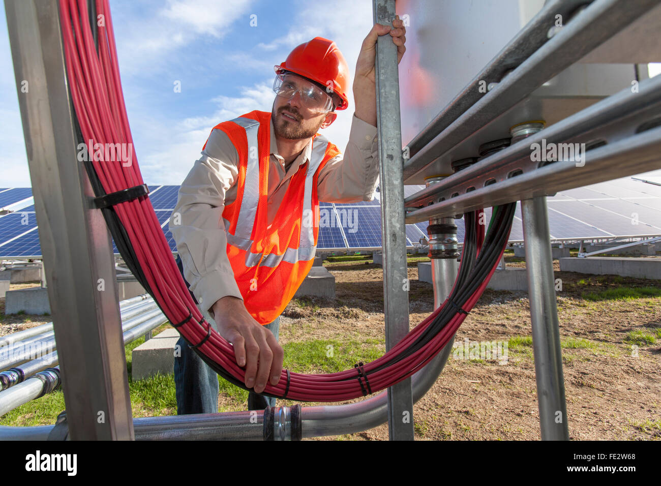 Solar photovoltaic installer working on power connections for a PV ...