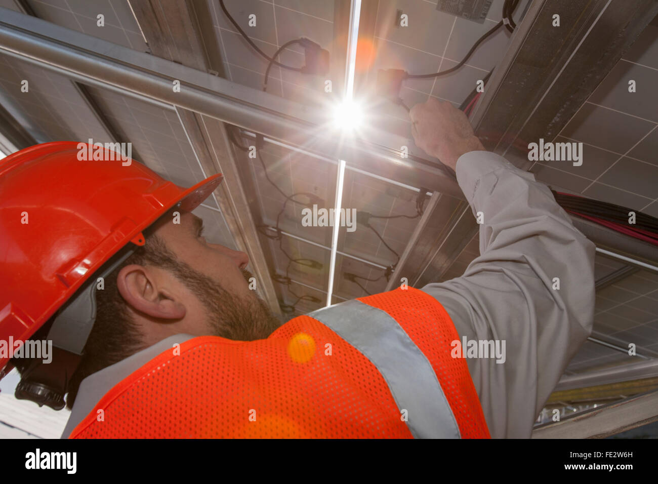 Solar photovoltaic installer working on power connections for a PV ...
