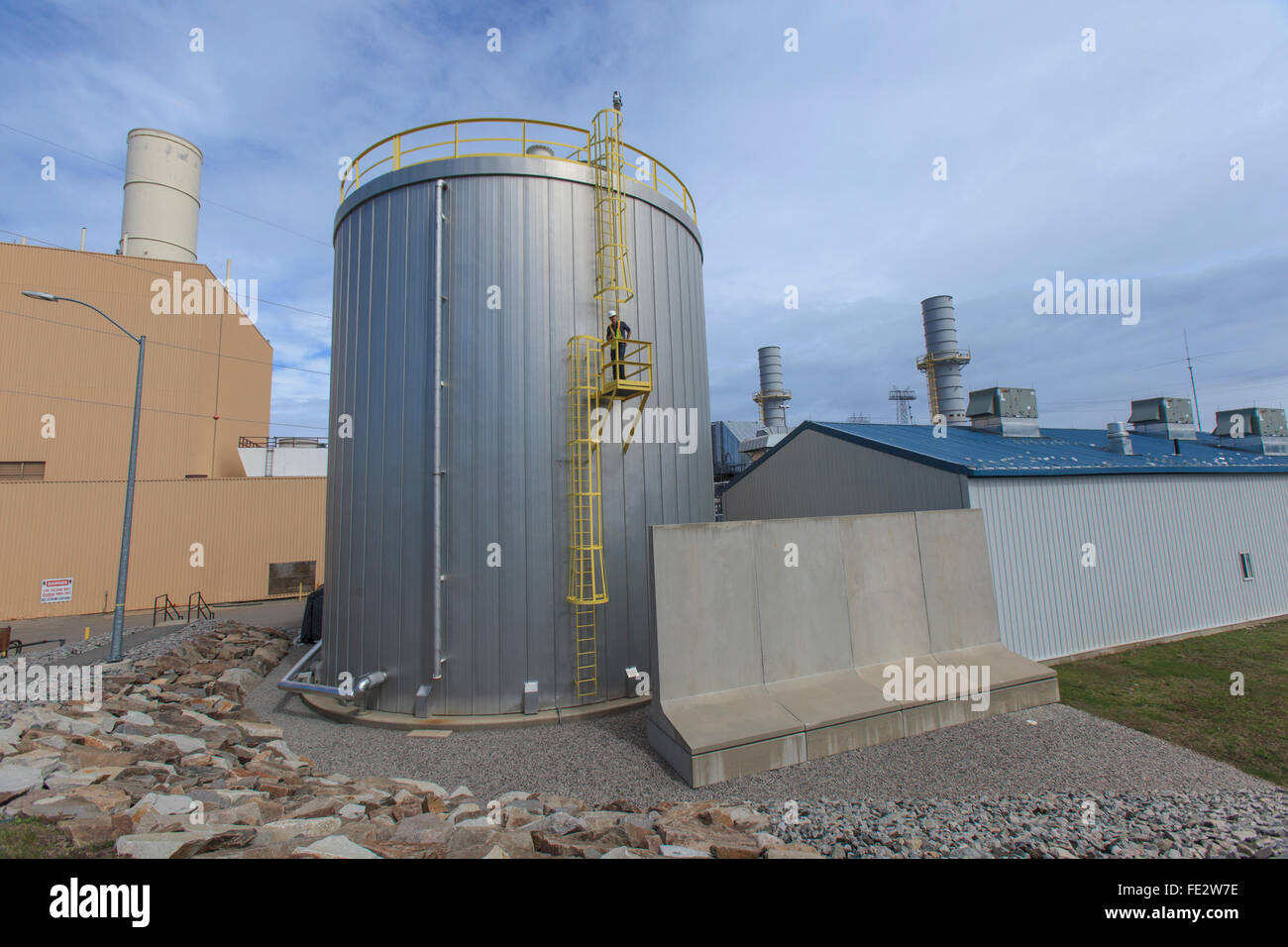 Industrial engineer climbing ladder with safety cage at a power plant ...