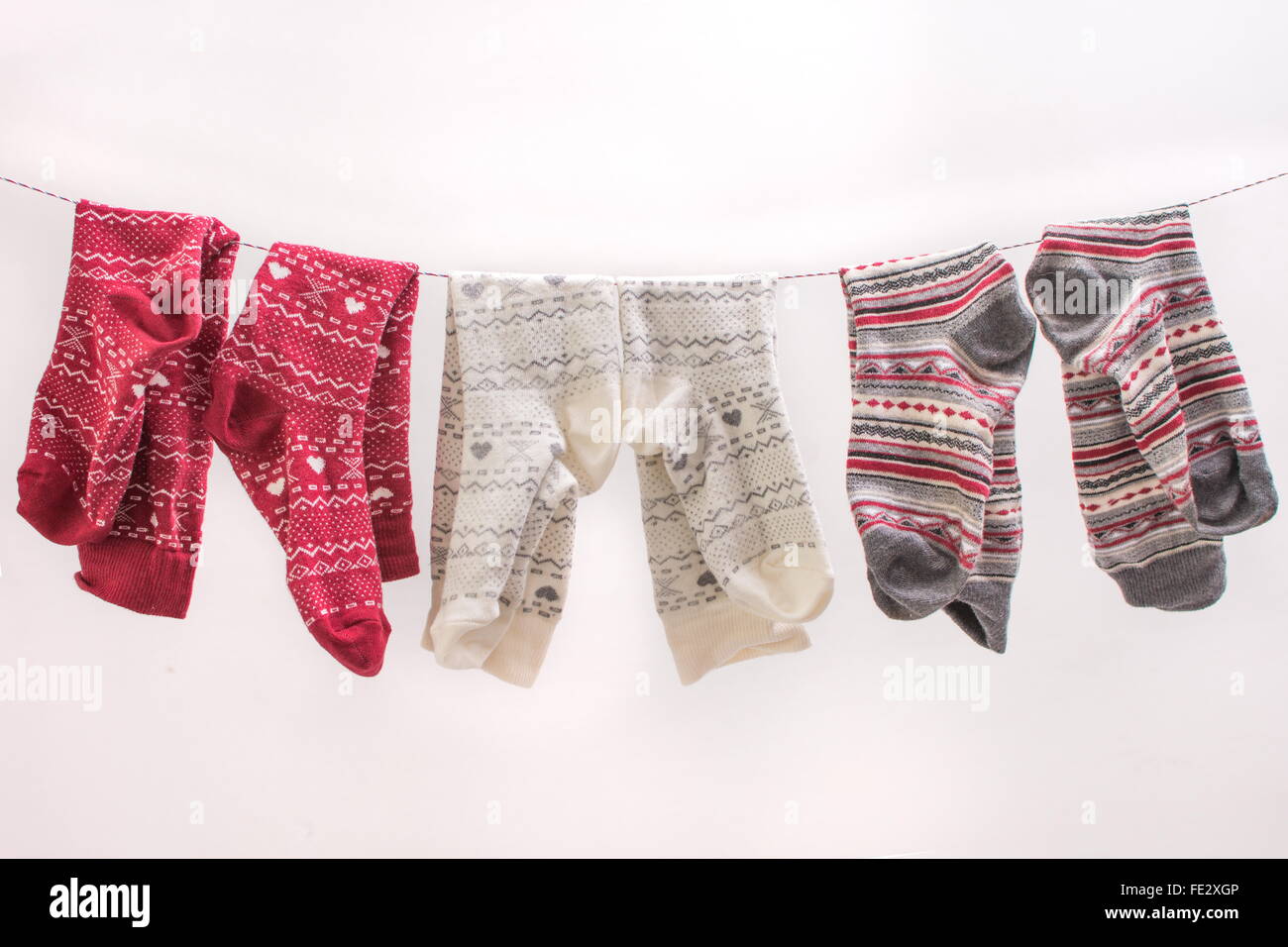 Various colored socks hanging from a wire Stock Photo - Alamy