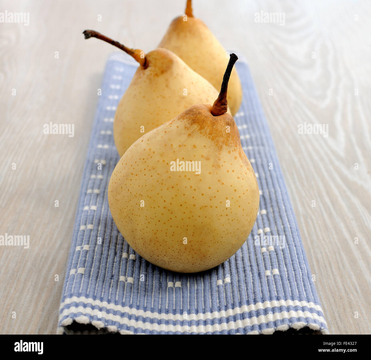 Three ripe yellow pears in a number on a napkin Stock Photo - Alamy