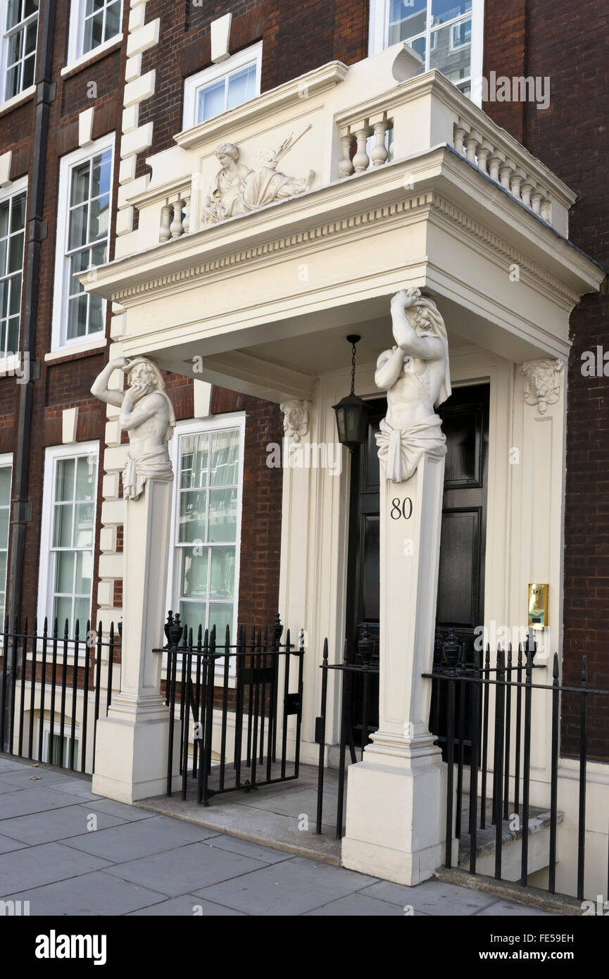 Two decorative columns with a man figure at the entrance of a house in ...