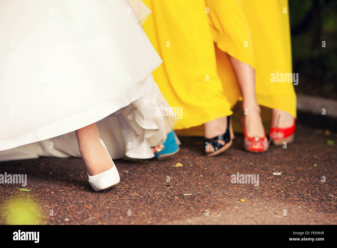 bride and bridesmaids in colourful dresses show feet Stock Photo - Alamy