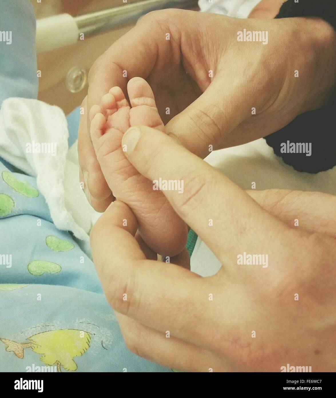 Cropped Image Of Mother Holding Baby Leg Stock Photo - Alamy