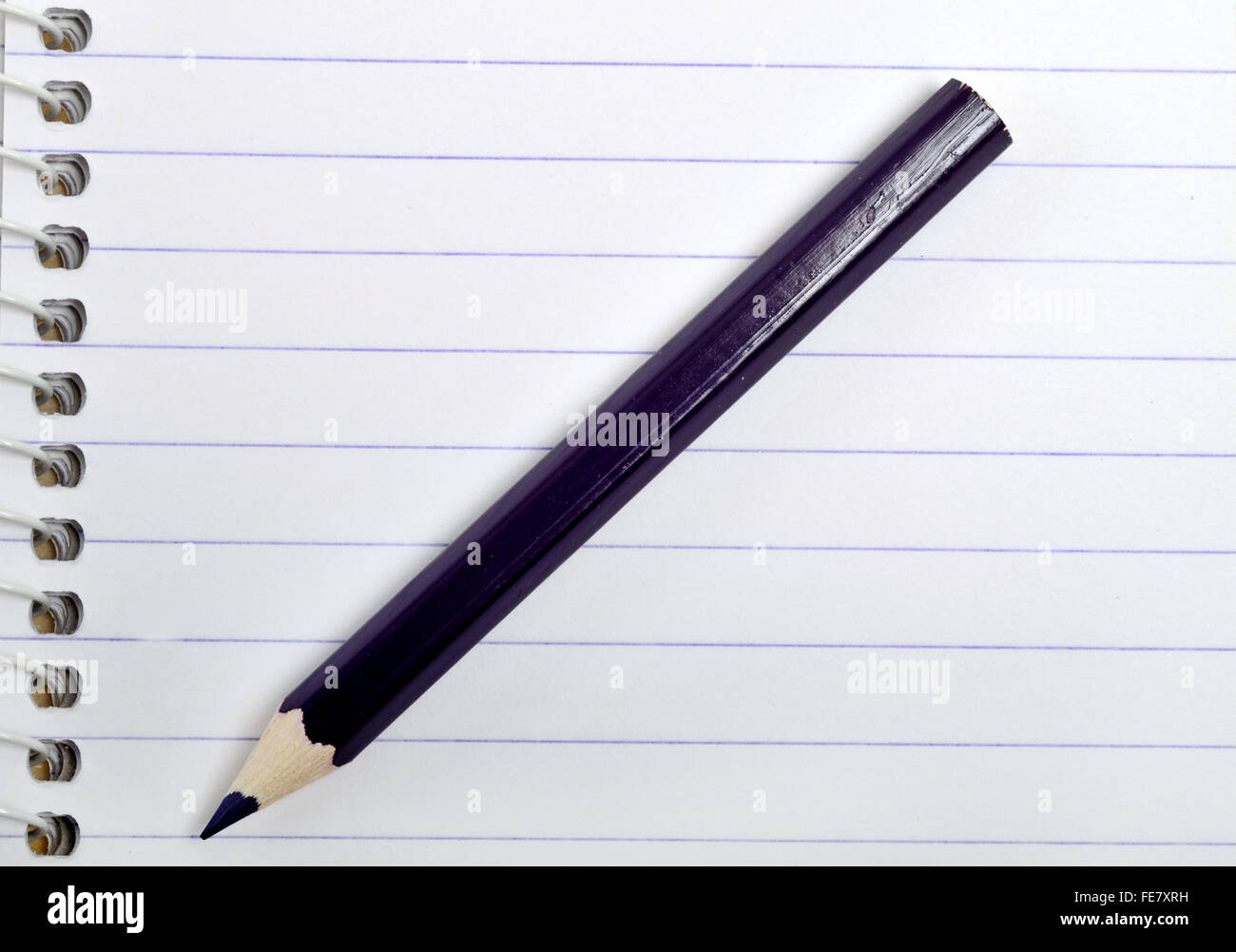 Closeup notebook with purple pencil Stock Photo - Alamy