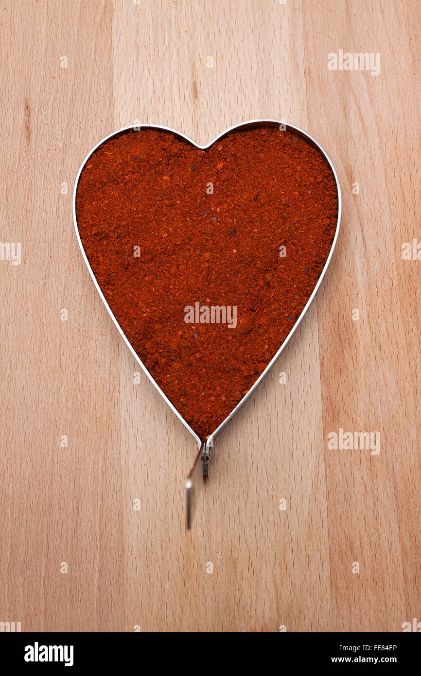 Heart filled with red pepper, chili flakes Stock Photo - Alamy