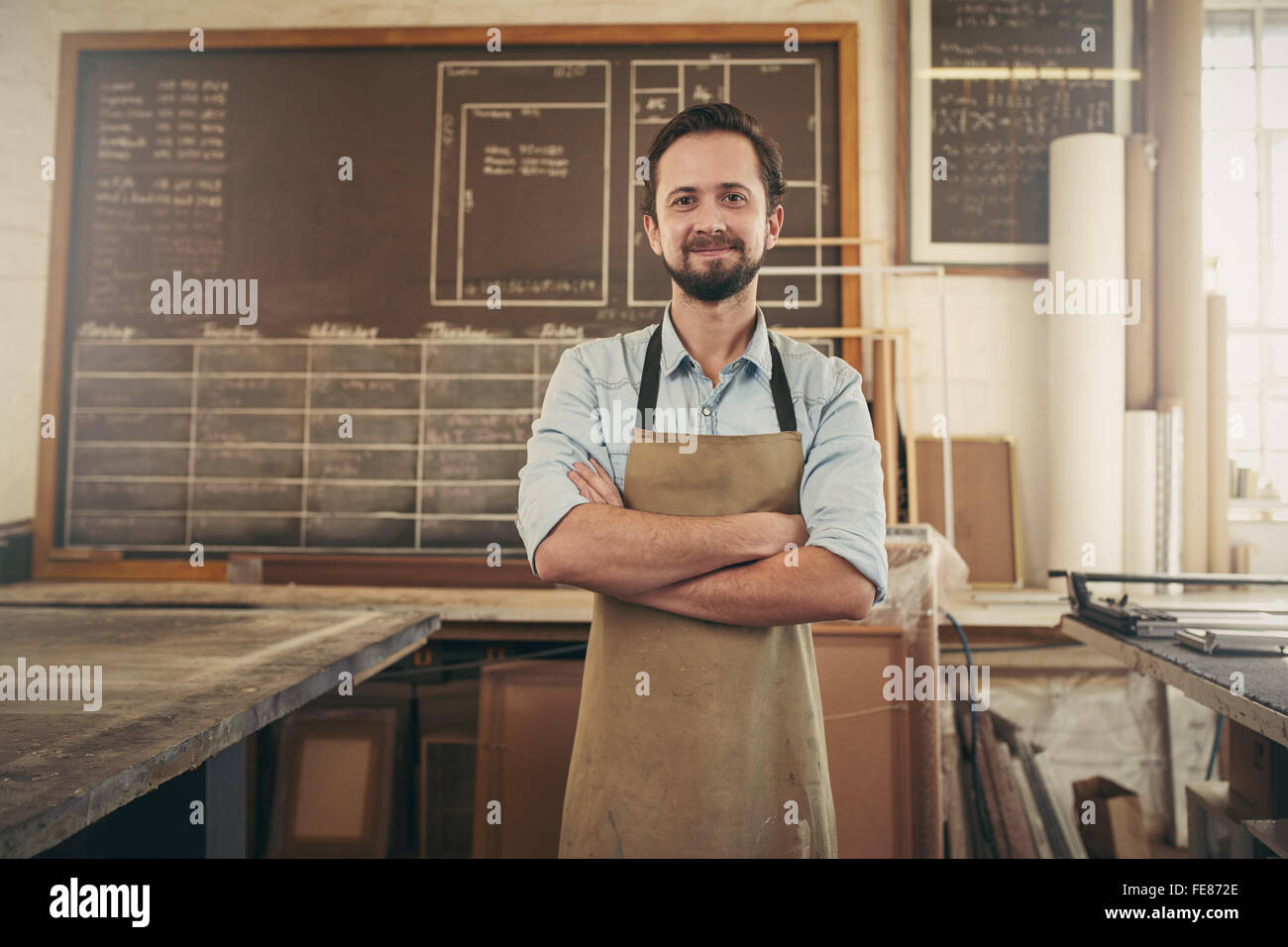 Portrait of a designer craftsman standing in his workshop studio with ...